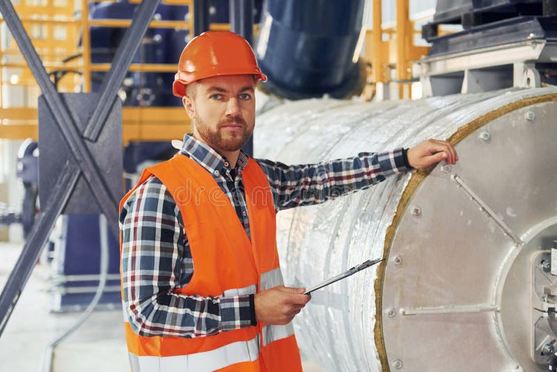 In Orange Colored Hard Hat. Construction Worker in Uniform is in the ...