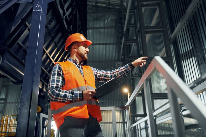 In Orange Colored Hard Hat. Construction Worker in Uniform is in the ...