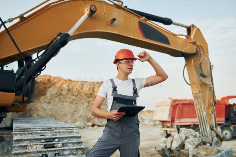 In Orange Colored Hard Hat. Worker in Professional Uniform is on the ...