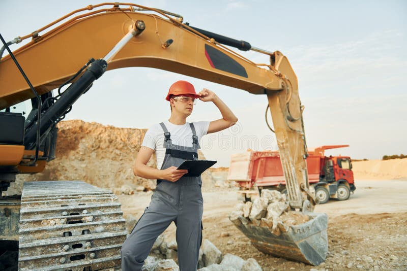 In Orange Colored Hard Hat. Worker in Professional Uniform is on the ...