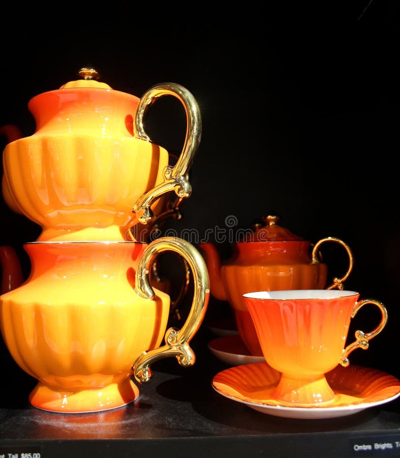 Orange Colored Tea Pots with Tea Cups Placed in a Shelf Stock Photo ...