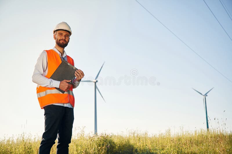Handsome Service Engineer is Standing on the Field with Windmills Stock ...