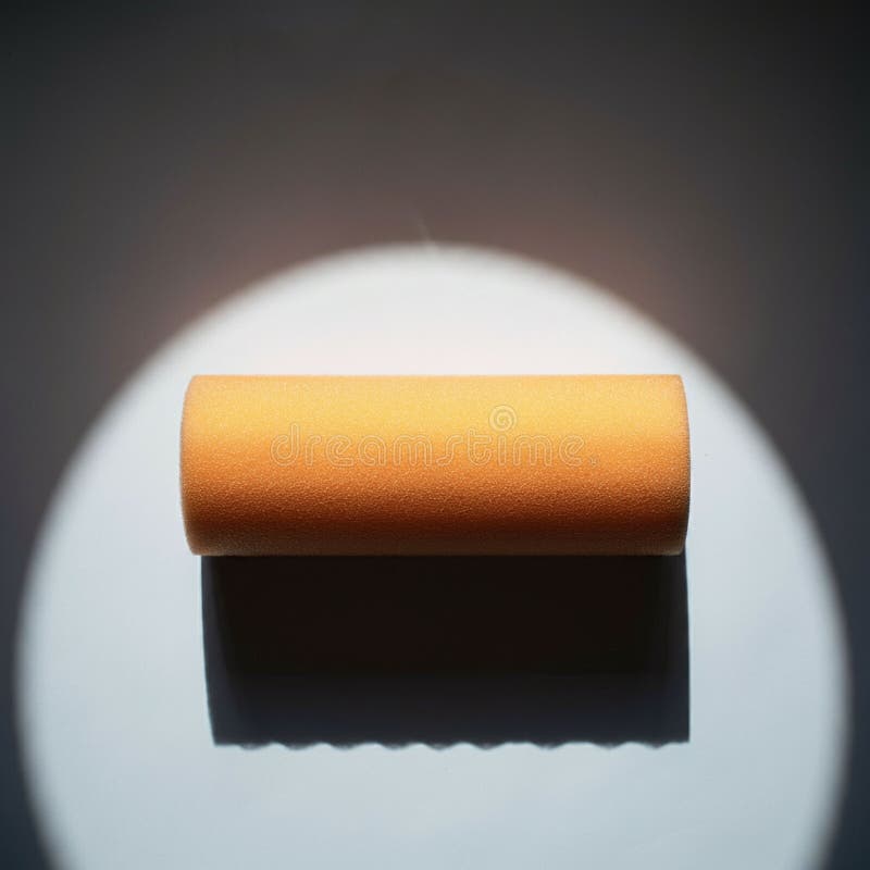 An Orange Cylindrical Foam Object is Placed Horizontally on a Flat ...