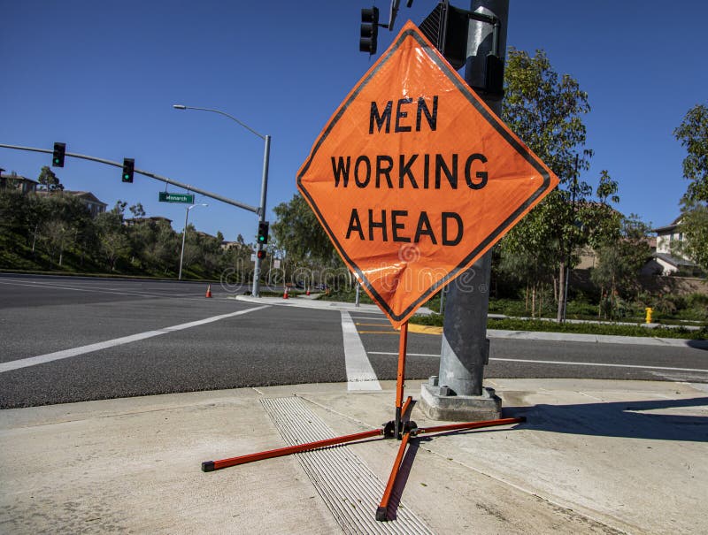 Orange Diamond Shaped Traffic Control Sign Reading â€œMen Working ...