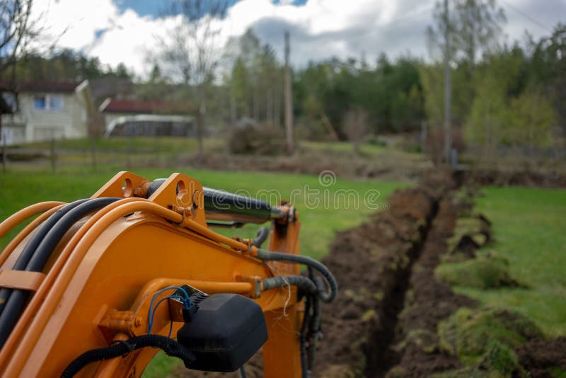 Orange Digger Digging the Ground of the House Backyard on the Blurred ...