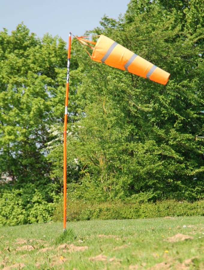 Orange Windsock Or Wind Vane In Moderate Wind On Red White Pole Against ...