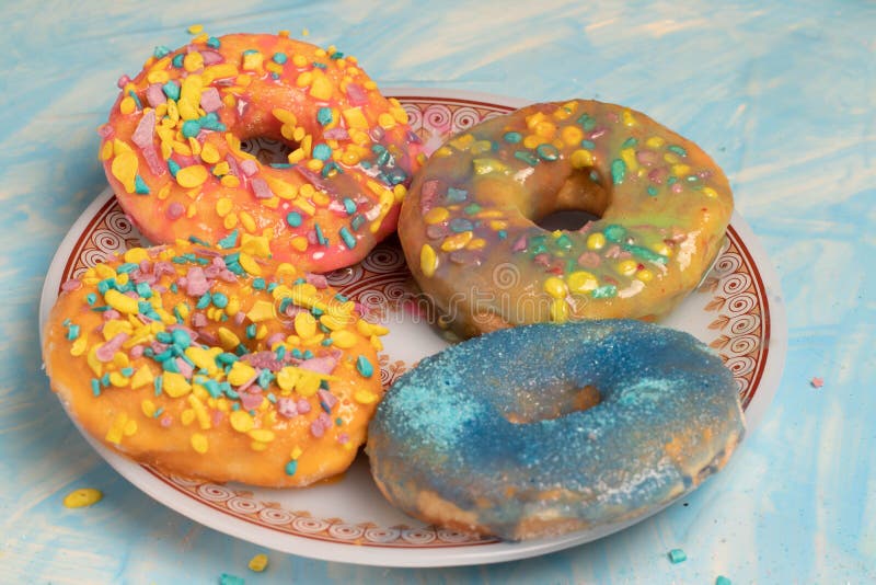 Orange Donuts with Many Colored Shavings on a Plate with Colored ...