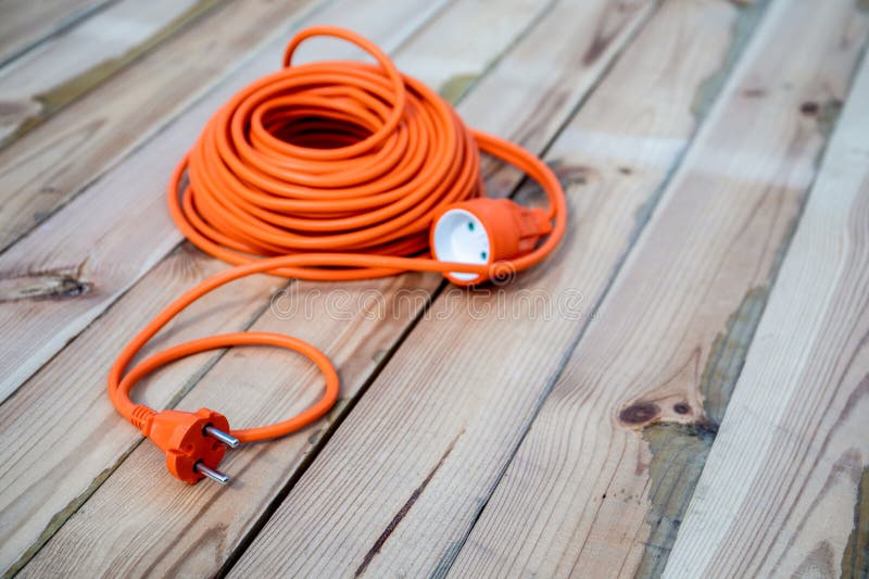 Orange Electrical Extension Cord Coiled on Wood Texture Background ...