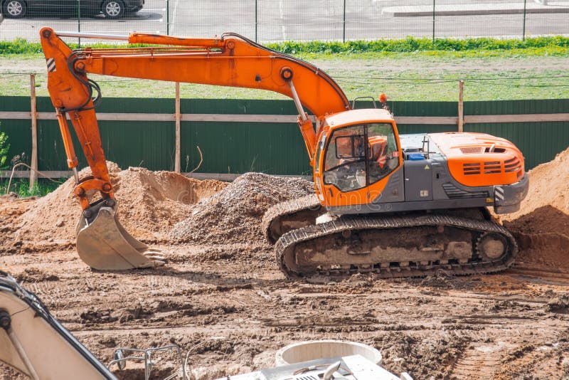 Excavator Loading Soil into Trucks in a Foundation Pit with Piles ...