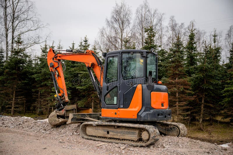 Orange Excavator with a Hydraulic Arm and Bucket at Construction Site ...