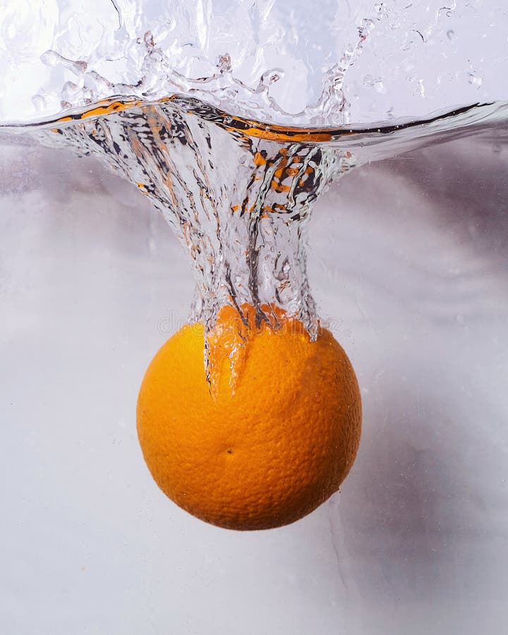Orange Falling into the Water and Creating Splashes Stock Image - Image ...