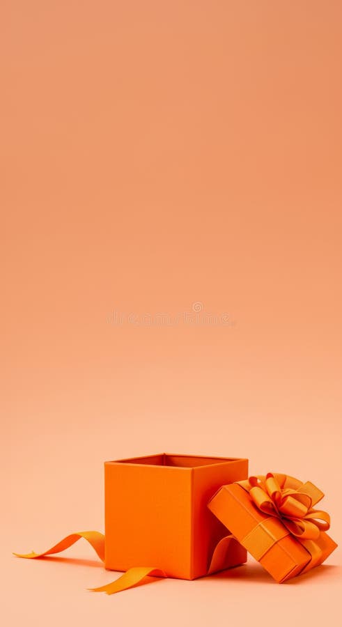 Orange Gift Box with Ribbon and Bow on Solid Peach Background Stock ...