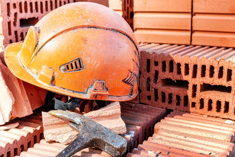 An Orange Hard Hat or Helmet for a Worker Lies on the Bricks. Safety in ...
