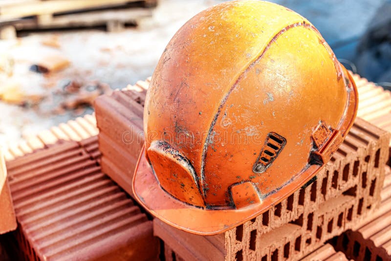 An Orange Hard Hat or Helmet for a Worker Lies on the Bricks. Safety in ...
