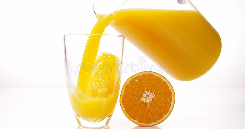 Orange Juice Being Poured into Glass Against White Background Stock ...