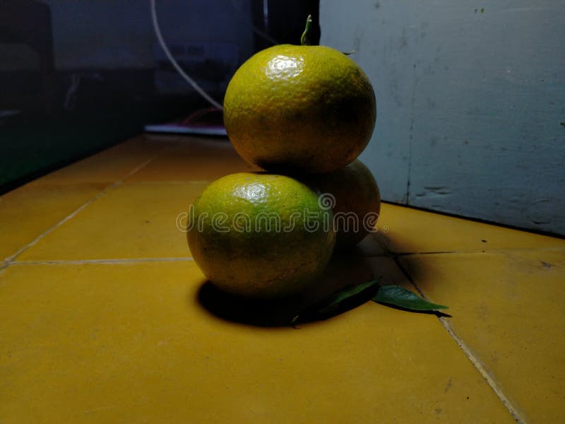 Three Oranges are Stacked on the Yellow Floor Dark Background and Blur ...