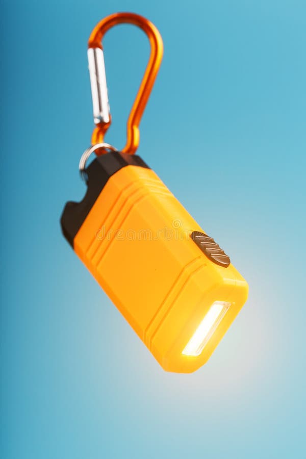 Orange Led Flashlight with a Carabiner on a Blue Background. LED Lights ...