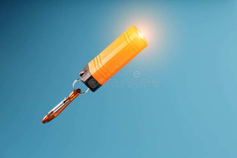 Orange Led Flashlight with a Carabiner on a Blue Background. LED Lights ...