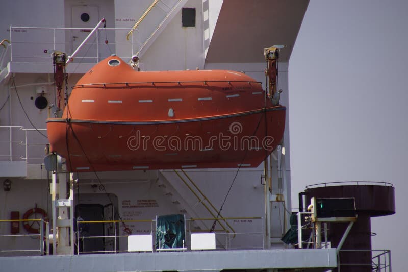 Orange lifeboat on a ship stock image. Image of metal - 345289607
