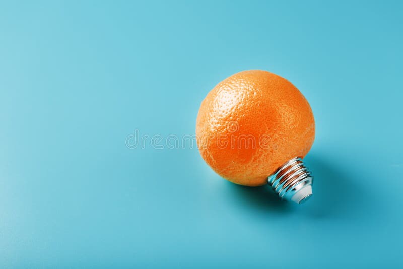 Orange Light Bulb on a Blue Background. the Concept of Fruit Ideas ...