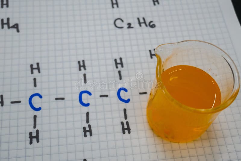 Orange Liquid-filled Beaker on the Notepad with Scientific Handwritten ...