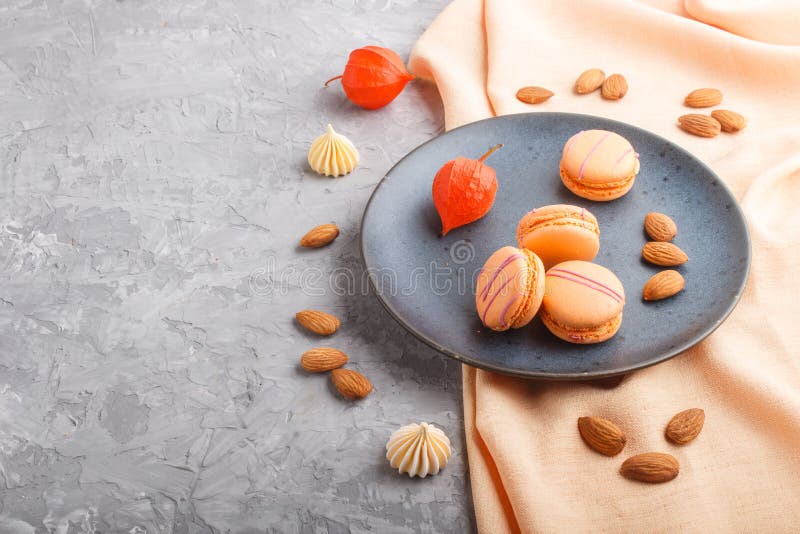 Orange Macarons or Macaroons Cakes on Blue Ceramic Plate on a Gray ...