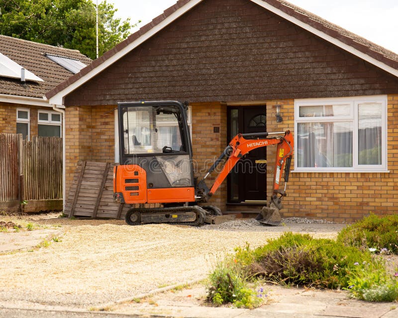 Orange Mini Excavator Digger Clearing Driveway in Front of Bungalow ...