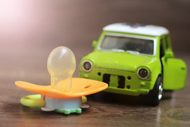 Orange Orthodontic Pacifier and a Car Toy Stock Photo - Image of rubber ...
