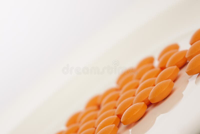 Orange Pain Killers on a White Plate with Reflections. Tilted View ...
