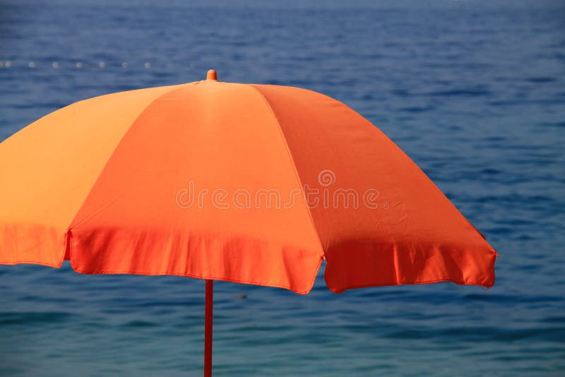 Orange Parasol on the Beach Stock Photo - Image of blue, parasol: 33130872