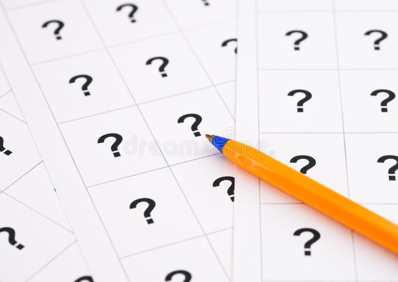 A Orange Pen Laying on Pieces of Paper that Have Question Marks on Them ...