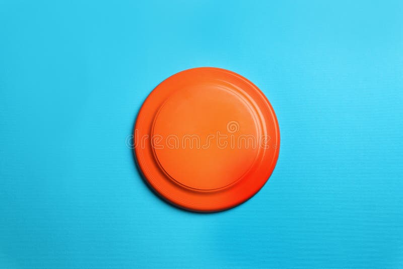 Orange Plastic Frisbee Disk on Light Blue Background, Top View Stock ...