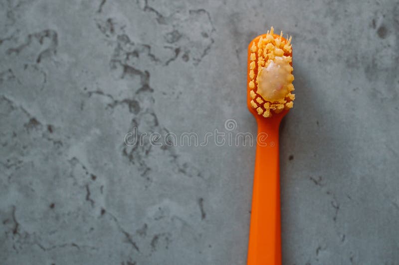 Orange Plastic Toothbrush with Toothpaste on Gray Concrete Table Stock ...