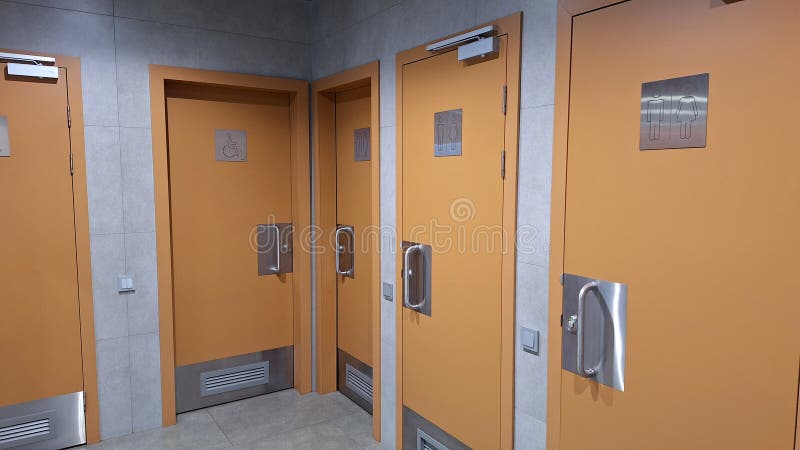 Orange Restroom Doors with Accessibility Signs in Modern Public ...