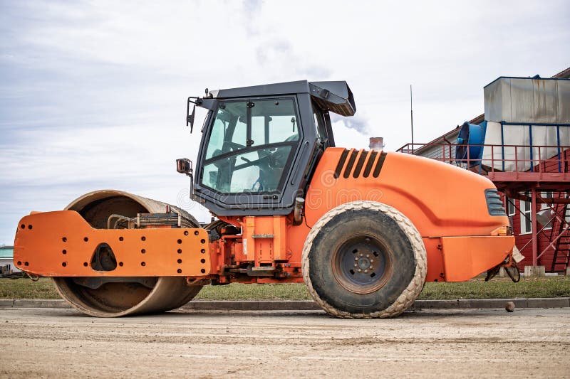 A Powerful Orange Road Roller Prepares To Smooth Out a Construction ...