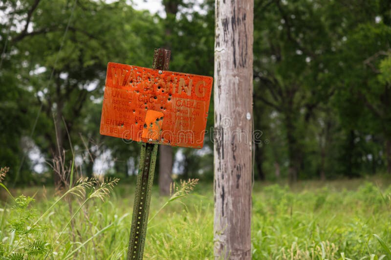 An Orange Sign with Bullet Holes is in the Middle of a Field Stock ...