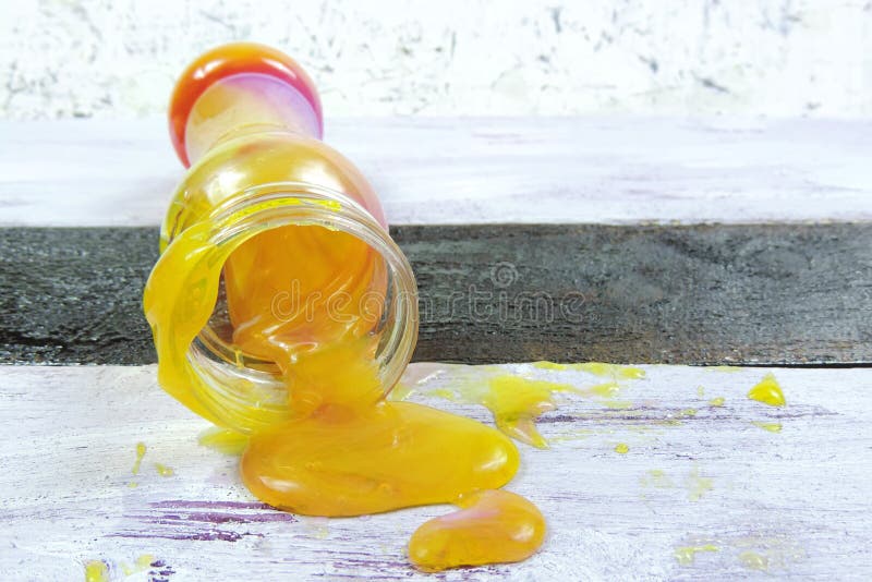 Orange Slime Flows Out of the Jar Onto a Wooden Surface . Stock Image ...