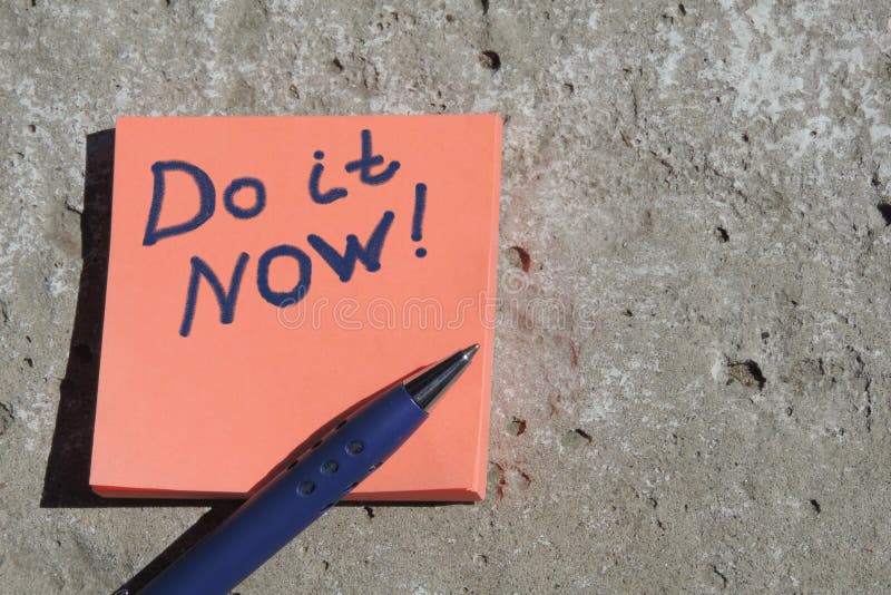 Orange Sticker with the Words Do it Now and a Pen on a Concrete Surface ...