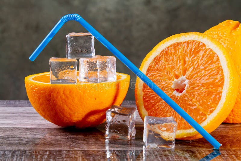 Orange with a Straw for Cocktails. Ice Orange. Juice with Ice Stock ...