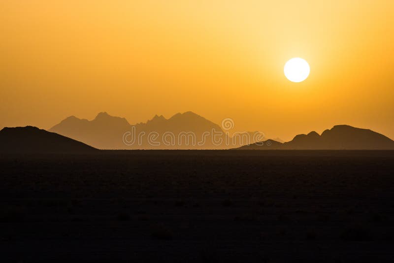 Orange Sunset Above Desert with Mountains in Background Stock Image ...