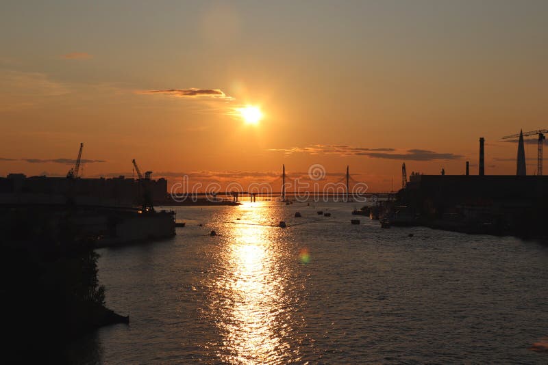 Orange Sunset Over the River with a Bridge and Boats Stock Photo ...