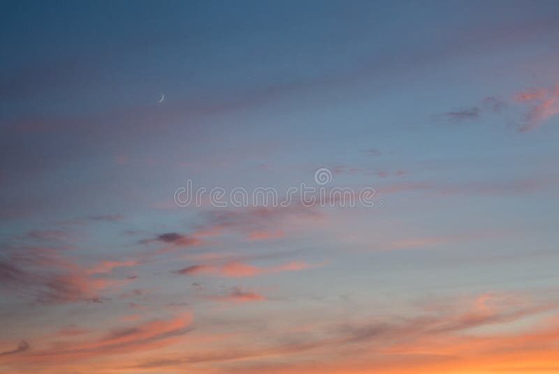 An Orange Sunset Sky with the Moon and Clouds Stock Photo - Image of ...