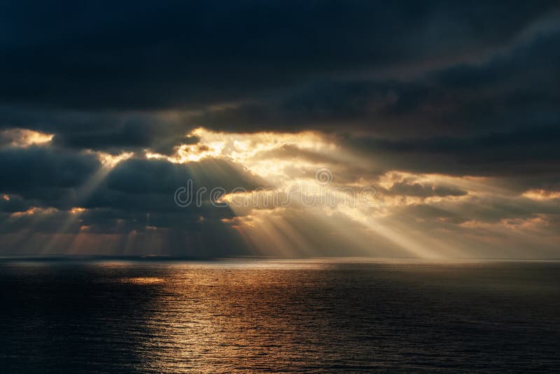 Sun Rays through Dark Clouds Over the Sea Stock Image - Image of ...
