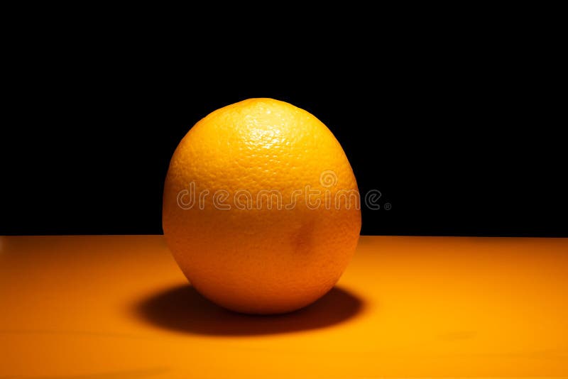 Orange on Orange Surface Illuminated by Warm Light on Black Background ...