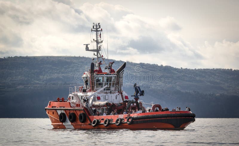 Orange tugboat in action editorial photography. Image of clouds - 27196552