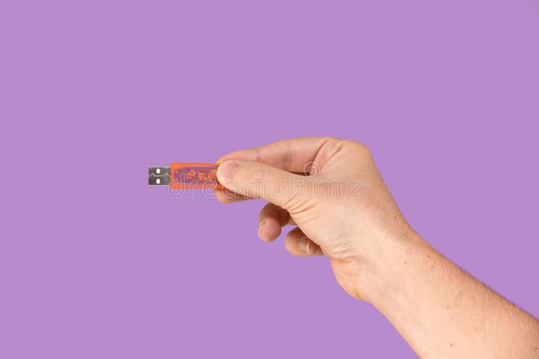 Orange USB Flash Memory on Hand with Isolated Violet Background Stock ...