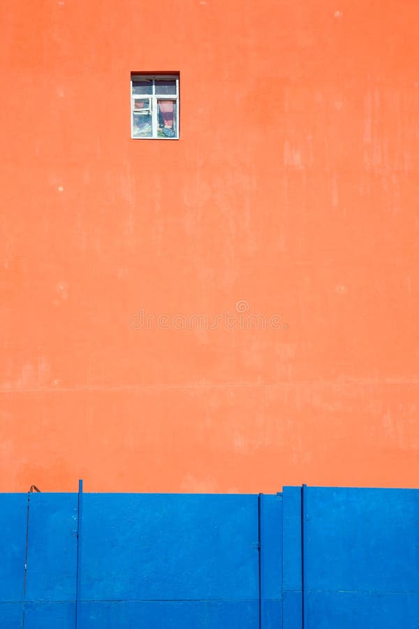 Orange Wall of a House with One Window Contrast with a Blue Fence. Back ...