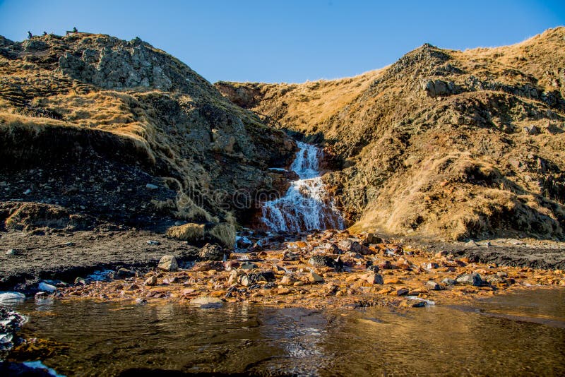 Orange Waterfall from Below, Framed by Rock Stock Photo - Image of ...