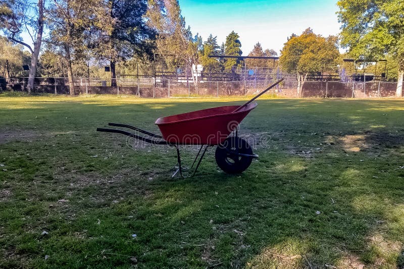 An Orange Wheelbarrow in Middle of a Field. Stock Image - Image of ...