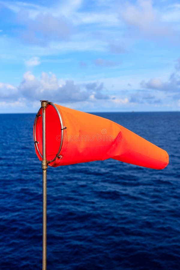 Orange Wind Sock in Blue Sky and Blue Sea with White Cloud Background ...